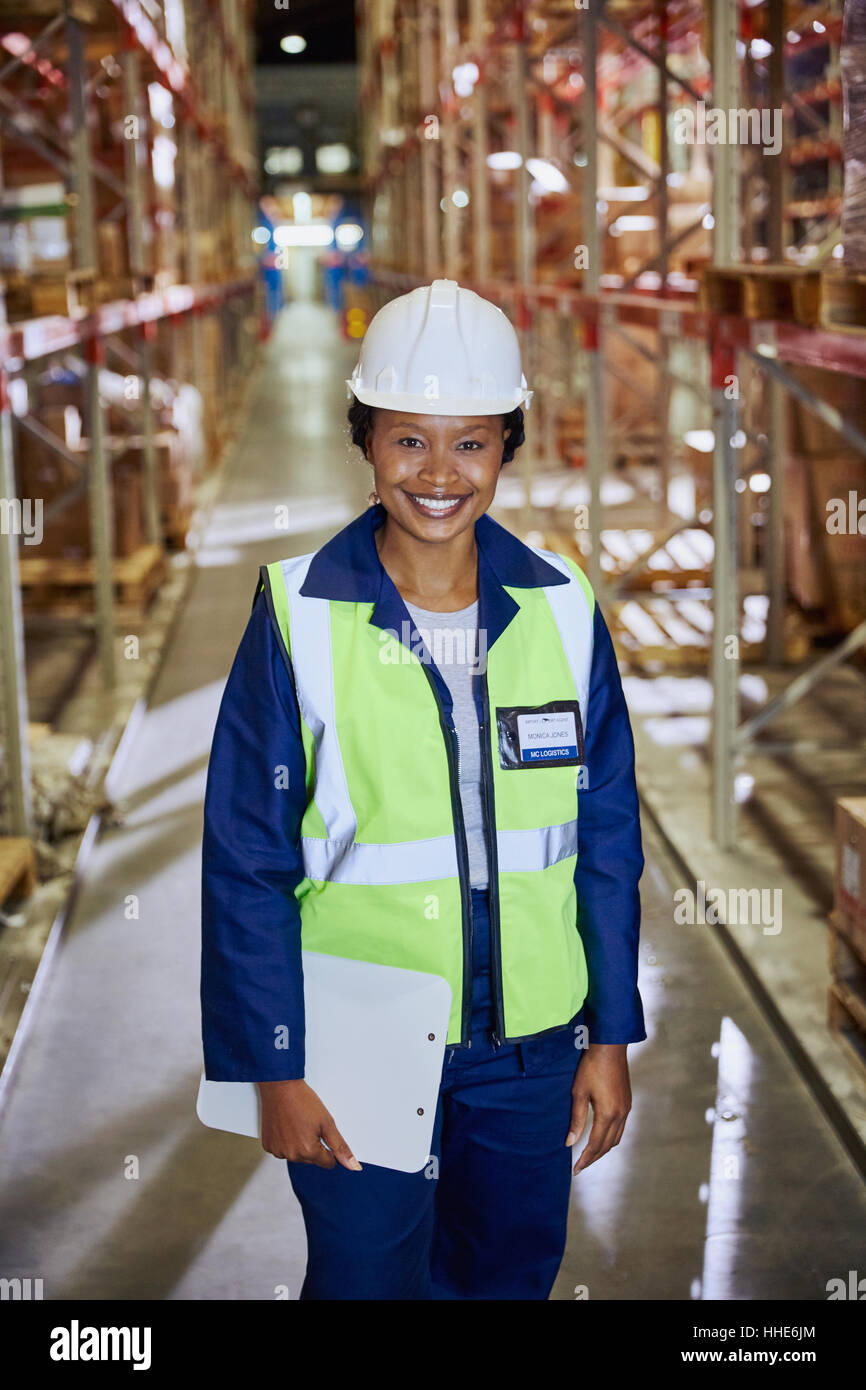 Portrait smiling female worker in distribution warehouse aisle Stock ...