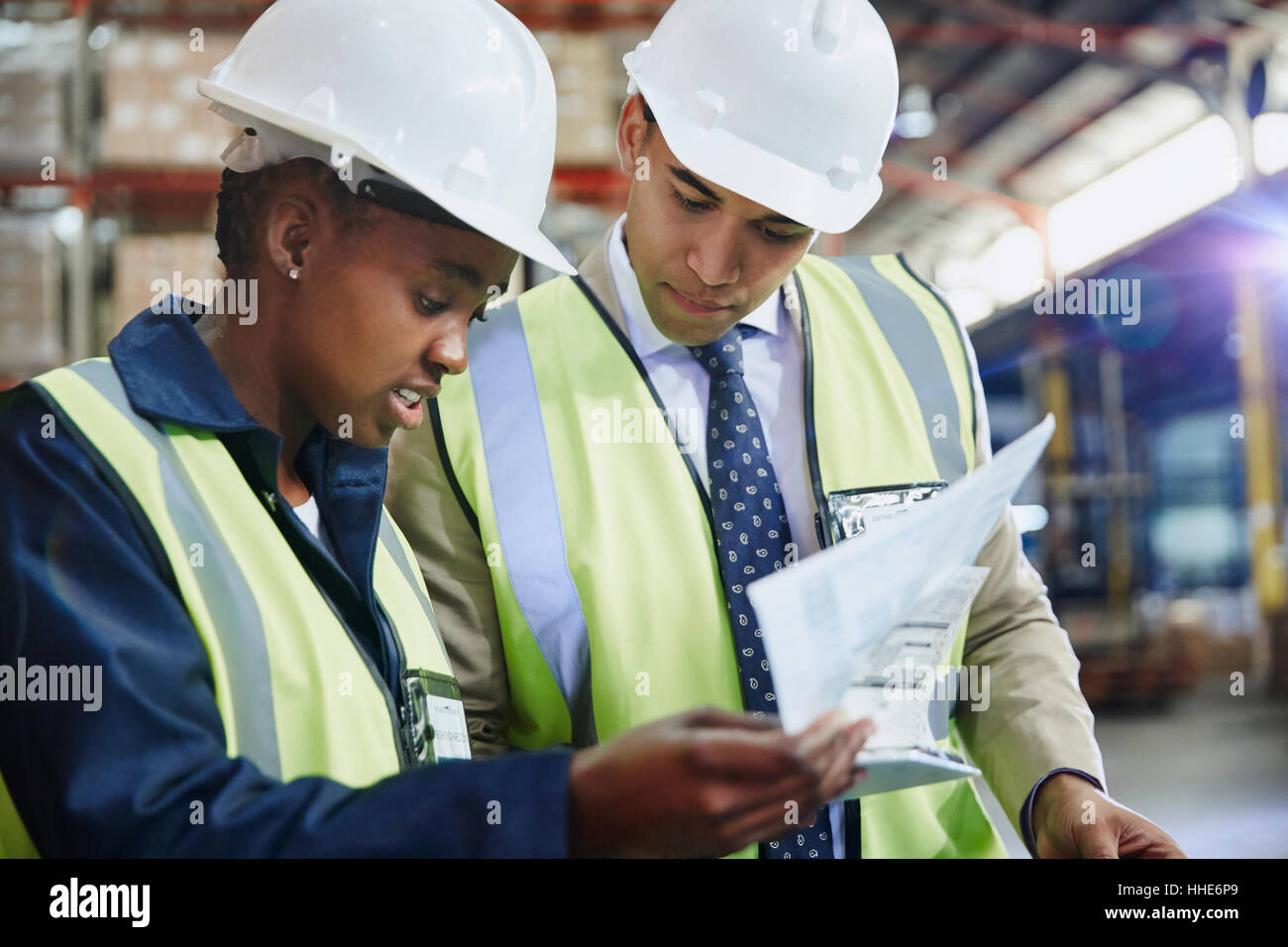Manager and worker reviewing paperwork in distribution warehouse Stock ...