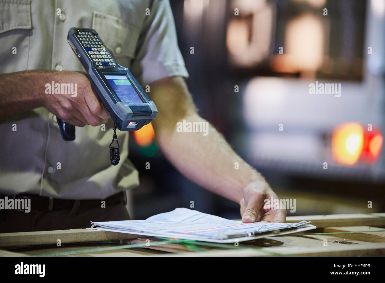 Worker with scanner scanning paperwork in distribution warehouse Stock ...