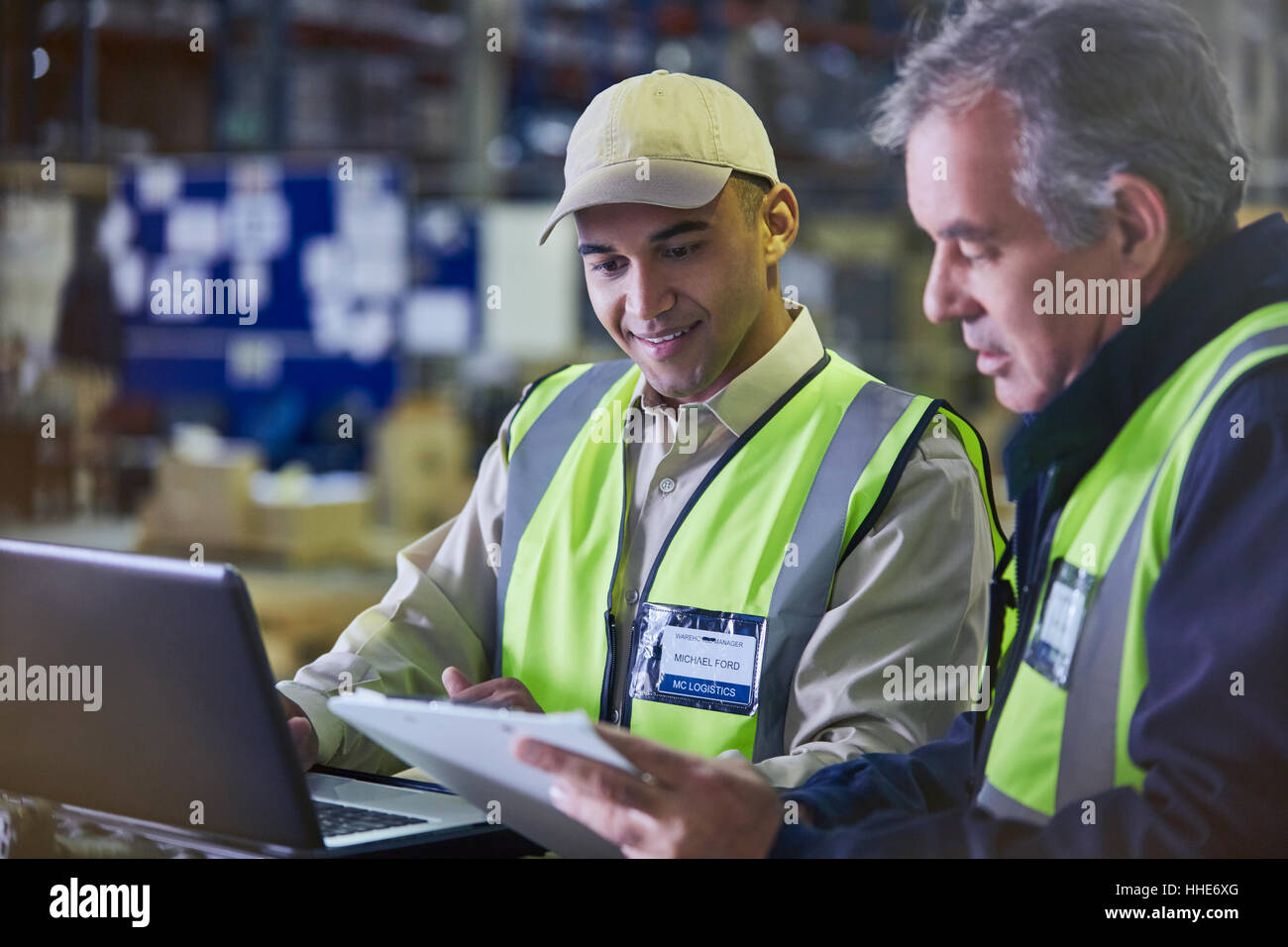 Workers with clipboard and laptop working in distribution warehouse ...