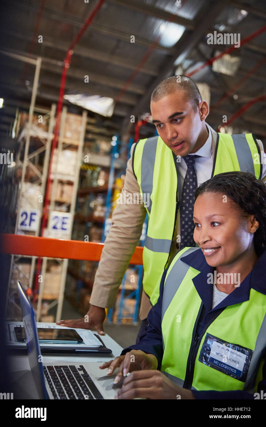 Manager and worker using laptop in distribution warehouse Stock Photo ...