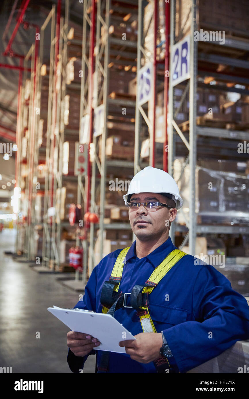 Serious worker with clipboard in distribution warehouse Stock Photo - Alamy