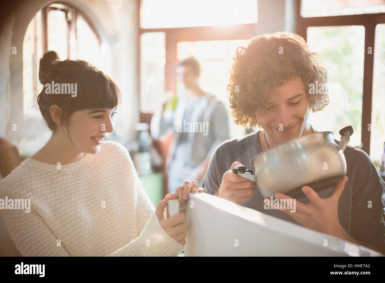 Young couple looking into pot at refrigerator Stock Photo - Alamy