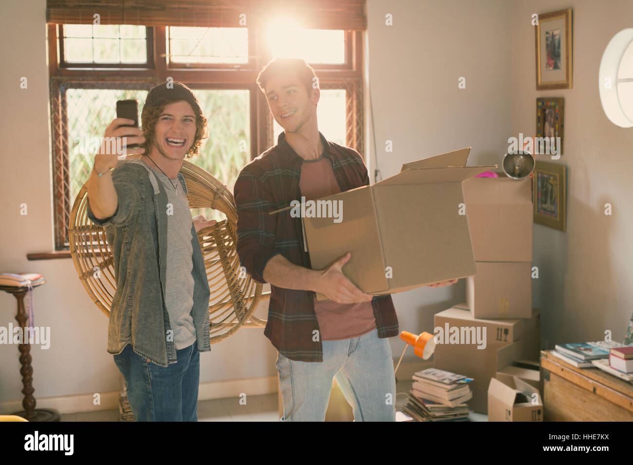 Young men roommates taking selfie moving boxes in apartment Stock Photo ...