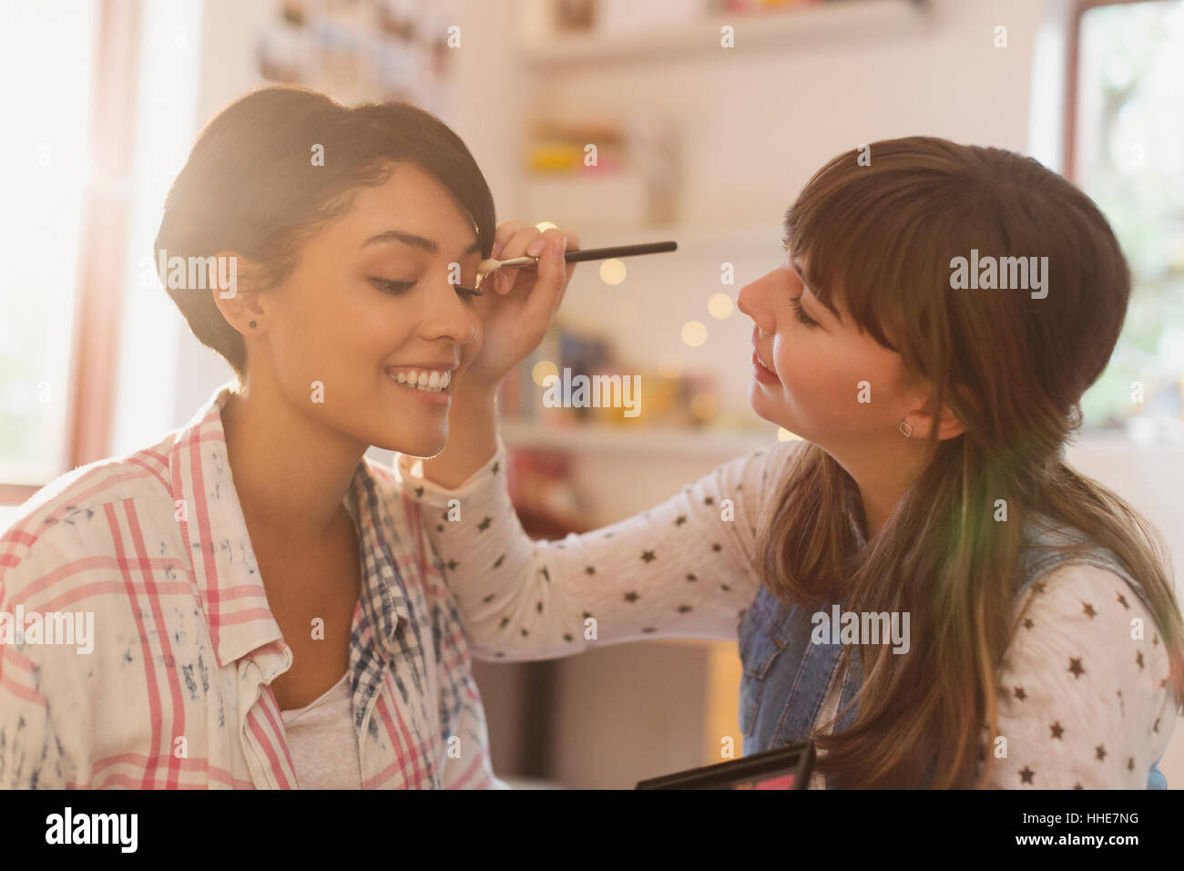 Young women friends applying makeup Stock Photo - Alamy