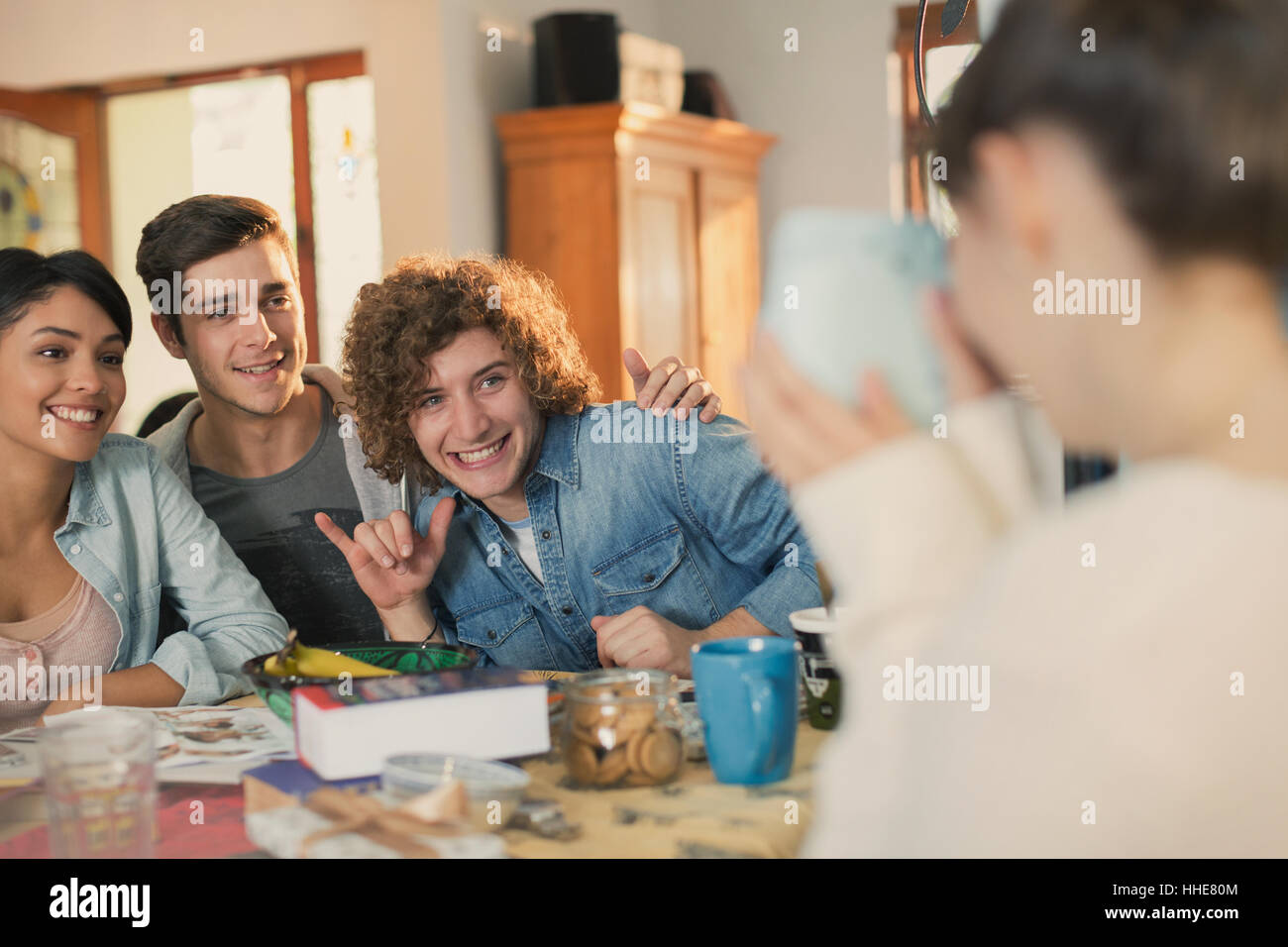Young woman photographing friends with instant camera Stock Photo - Alamy