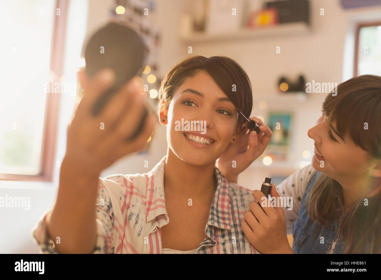 Young women friends applying makeup Stock Photo - Alamy