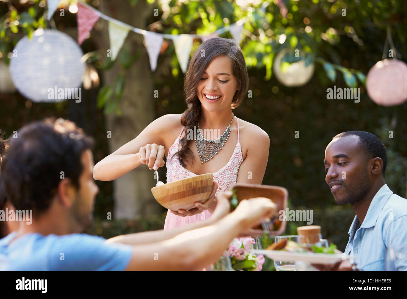 Woman Serving Food To Friends At Outdoor Backyard Party Stock Photo - Alamy