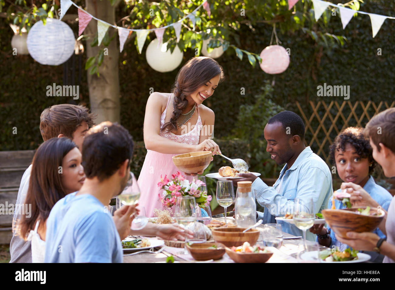 Woman Serving Food To Friends At Outdoor Backyard Party Stock Photo - Alamy