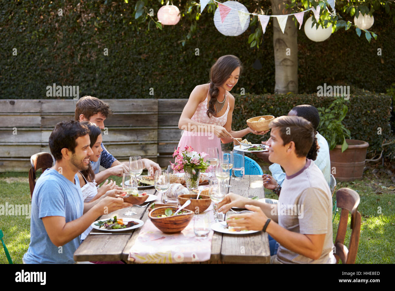 Woman Serving Food To Friends At Outdoor Backyard Party Stock Photo - Alamy