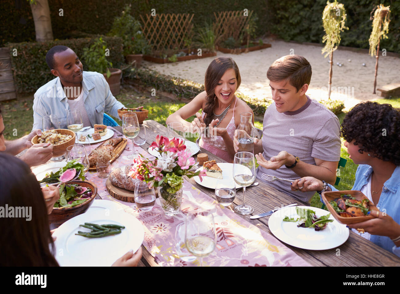 Friends Eating And Drinking Around Table At Outdoor Party Stock Photo ...
