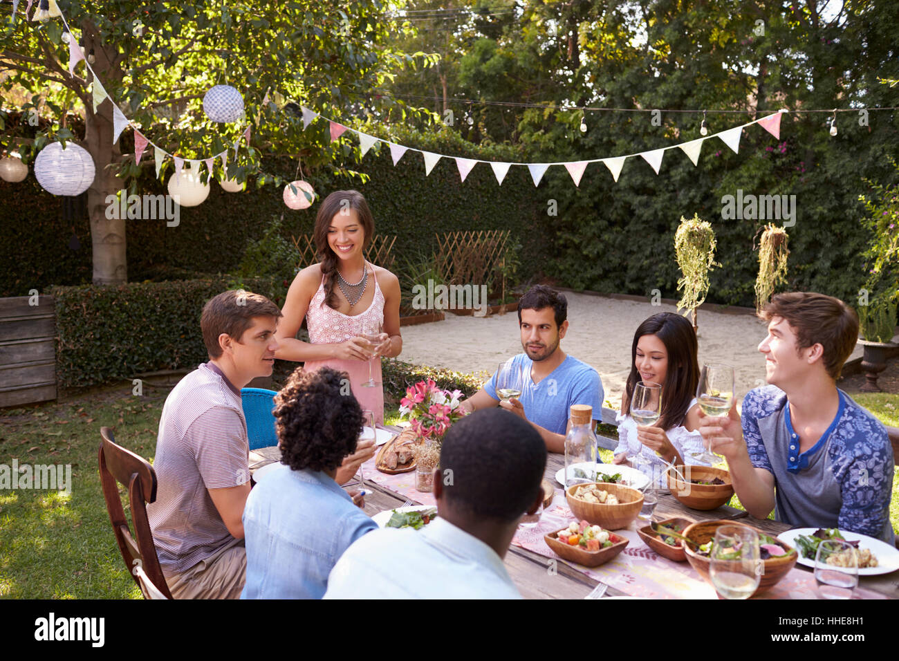 Friends Eating And Drinking Around Table At Outdoor Party Stock Photo ...