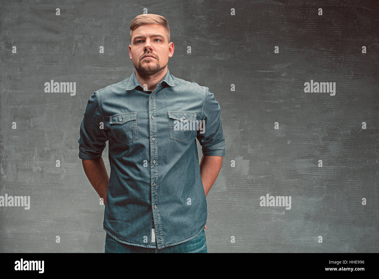 Portrait of serious man standing on the chair in studio Stock Photo - Alamy