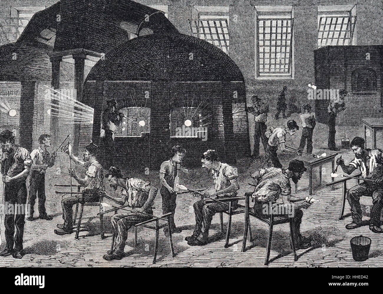 General view of a glassworks, showing men engaged in the various stages ...