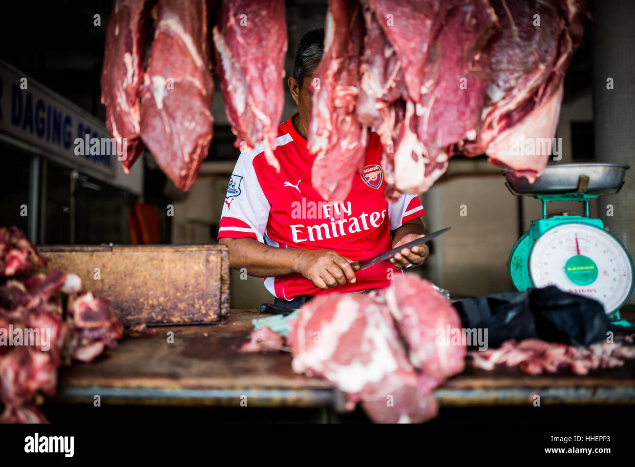 A butcher prepares cuts of meat in Kota Kinabalu, Malaysian Borneo ...