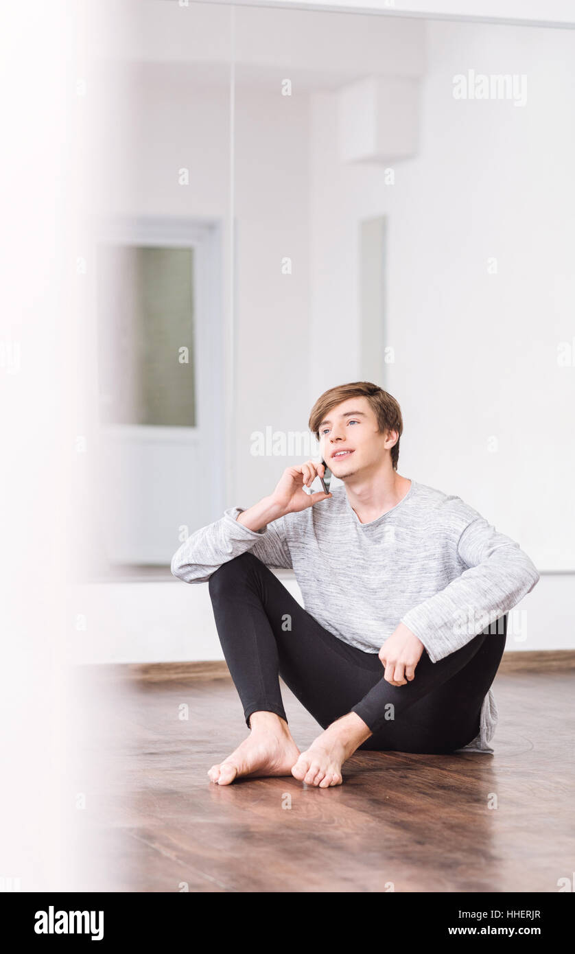 Positive nice dancer holding a cell phone Stock Photo - Alamy