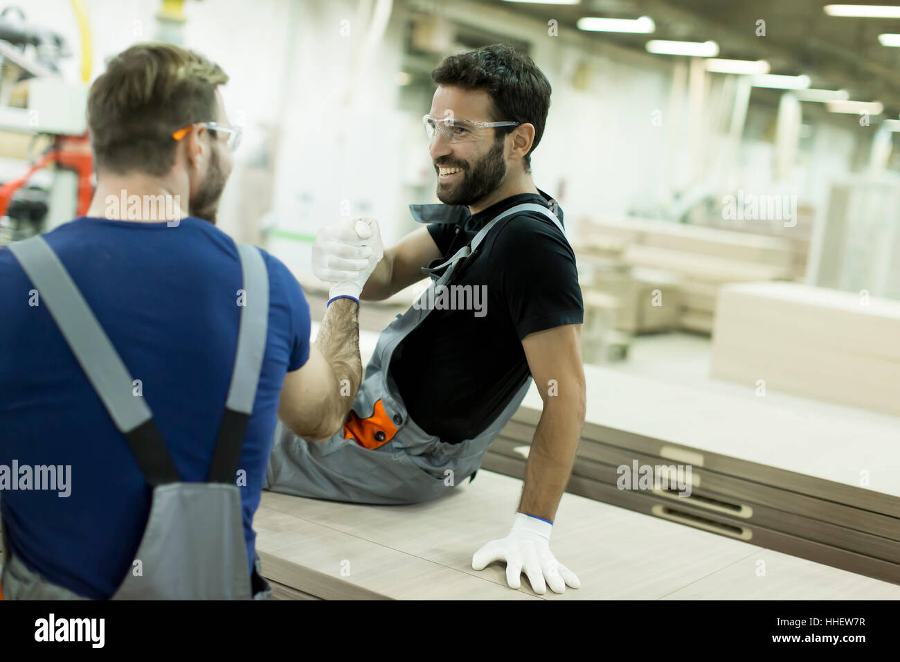 Young male workers in a furniture factory taking a rest Stock Photo - Alamy
