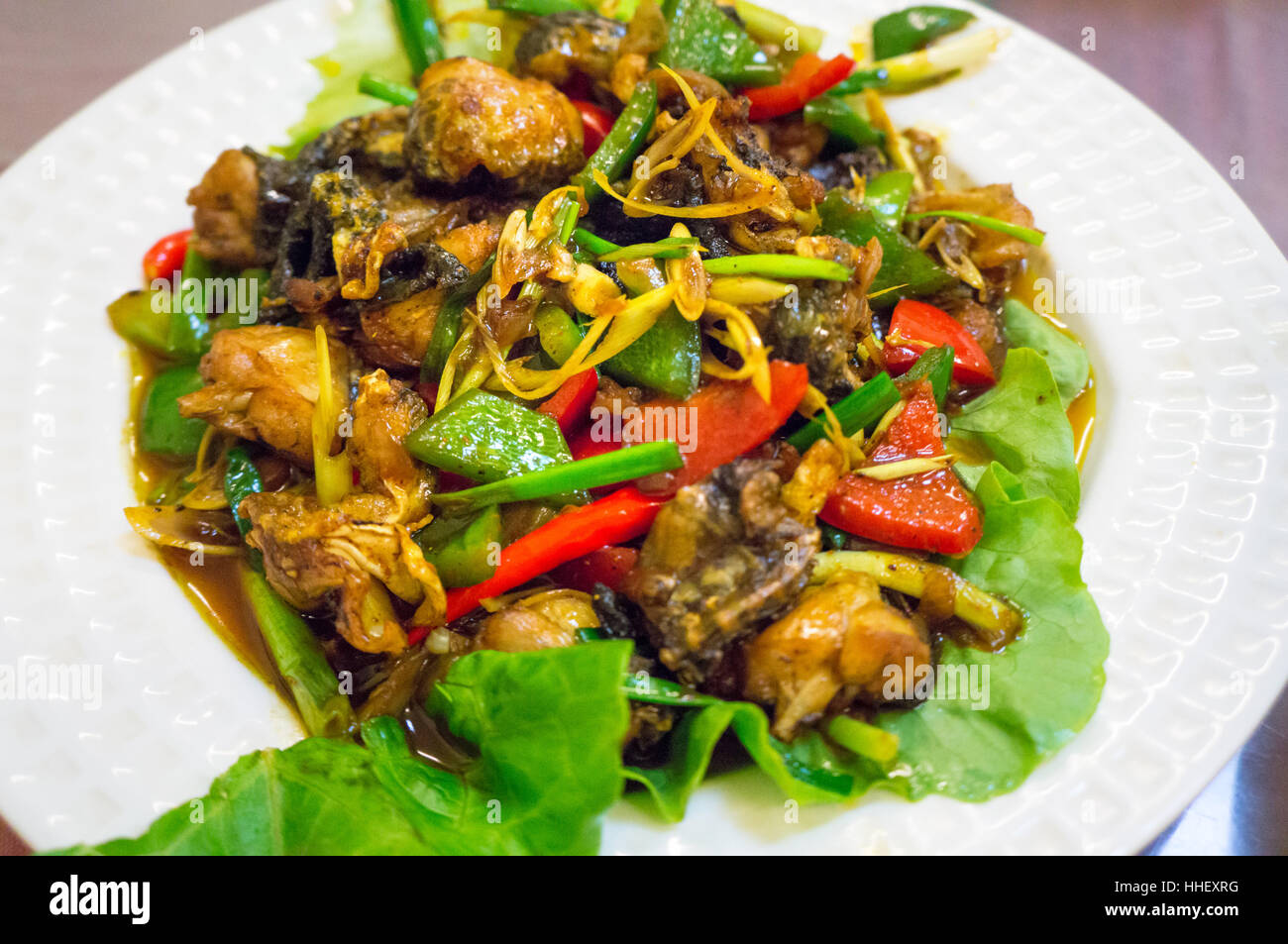 fried frog meat with green and red peppers on the plate Stock Photo - Alamy
