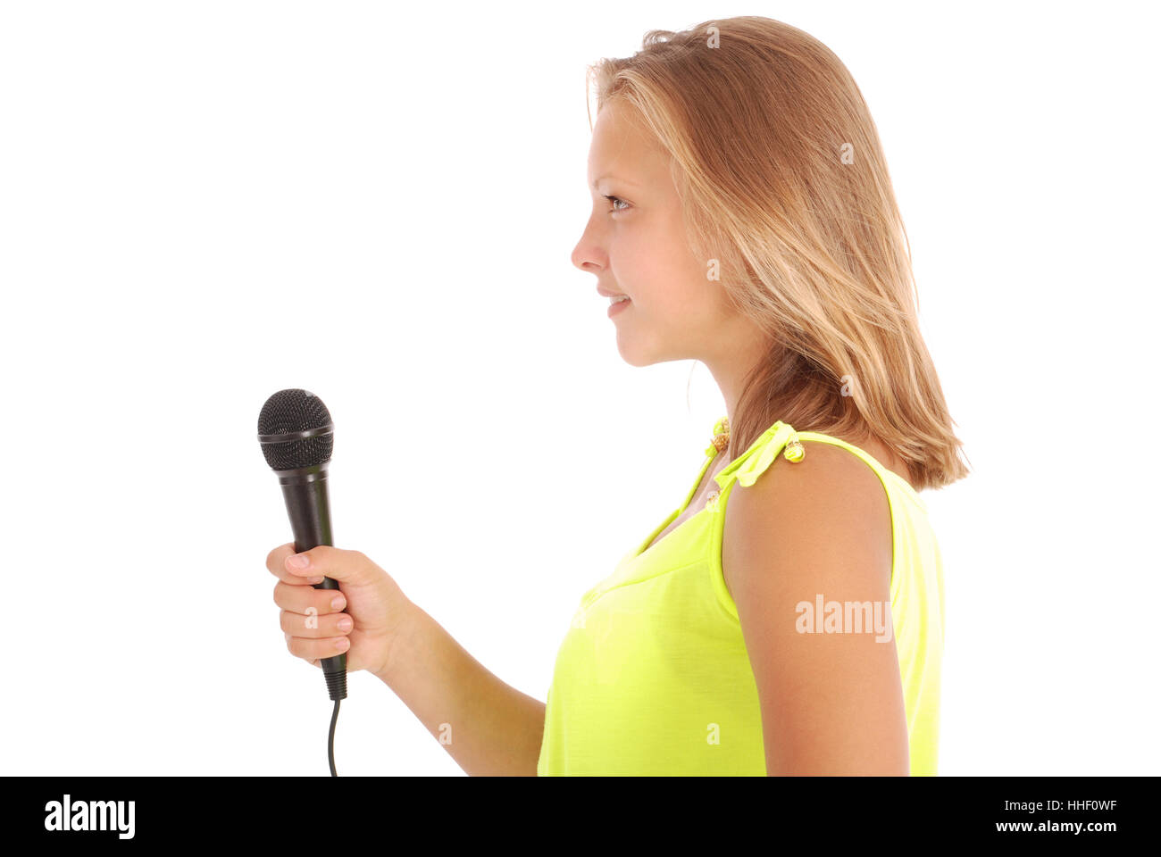 Beautiful teenage girl with microphone isolated on white background ...