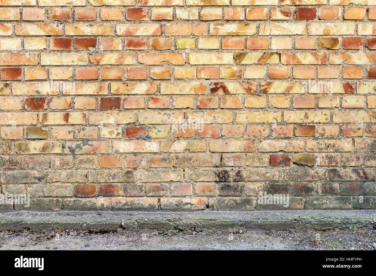 Yellow brick wall background with concrete basement Stock Photo - Alamy