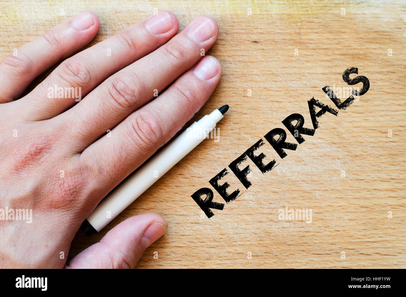 Human hand over wooden background and referrals text concept Stock ...
