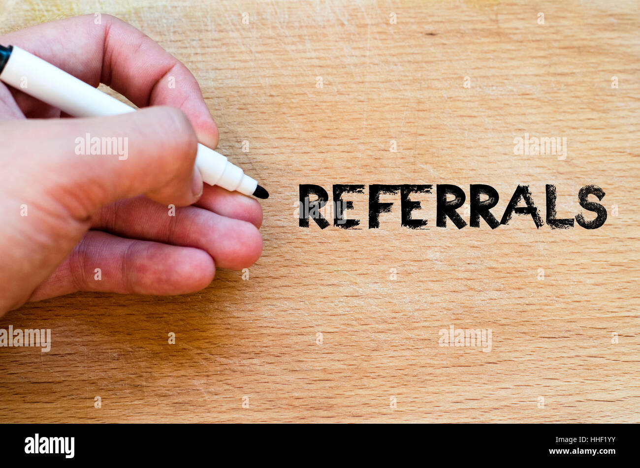 Human hand over wooden background and referrals text concept Stock ...