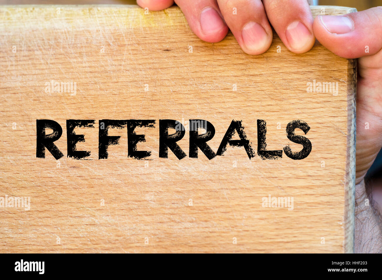 Human hand over wooden background and referrals text concept Stock ...