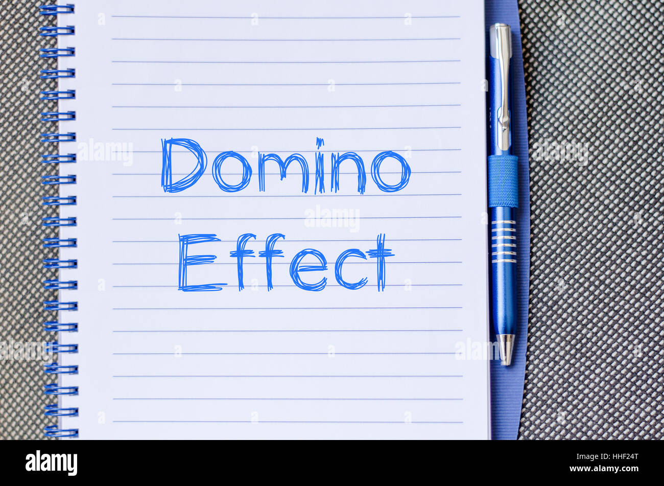 Domino effect text concept write on notebook Stock Photo - Alamy