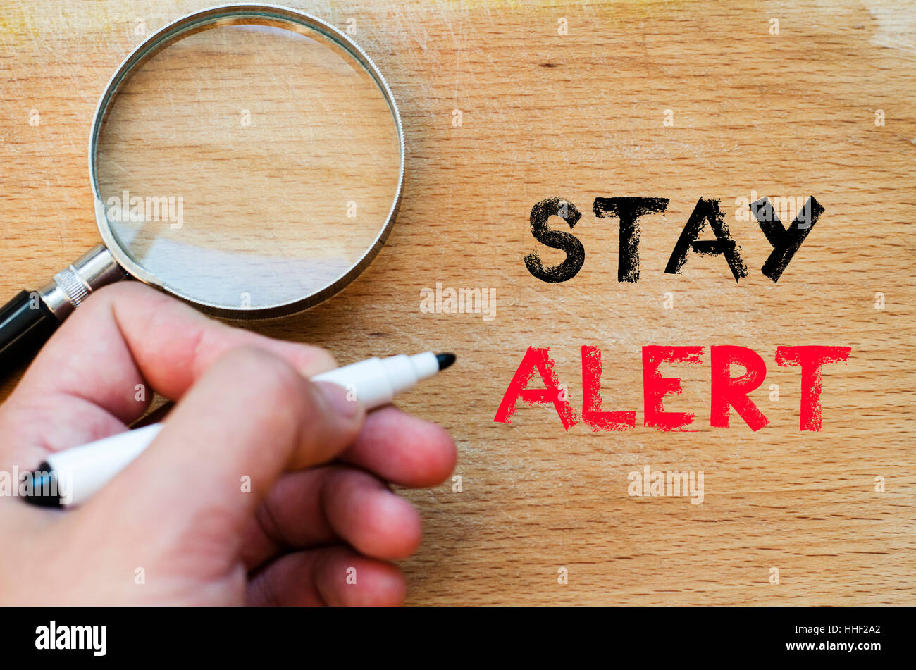 Human hand over wooden background and stay alert text concept Stock ...