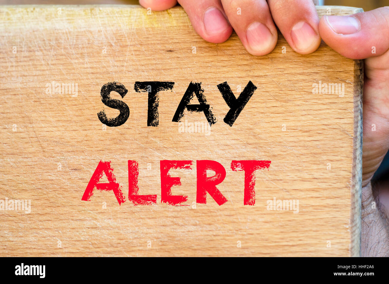 Human hand over wooden background and stay alert text concept Stock ...