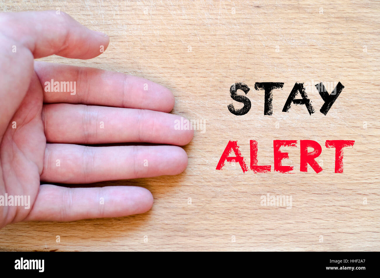 Human hand over wooden background and stay alert text concept Stock ...