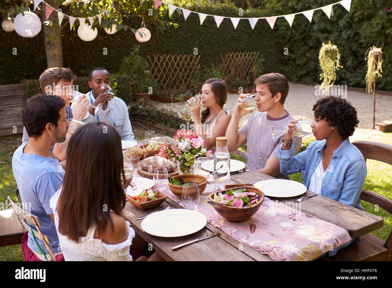 Friends Eating And Drinking Around Table At Outdoor Party Stock Photo ...