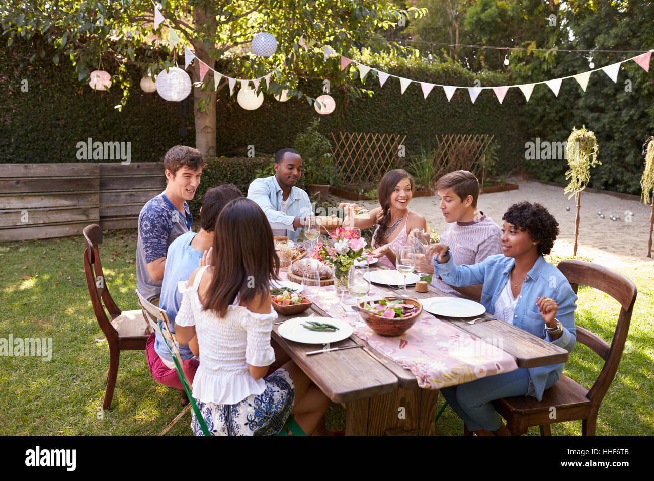 Friends Eating And Drinking Around Table At Outdoor Party Stock Photo ...