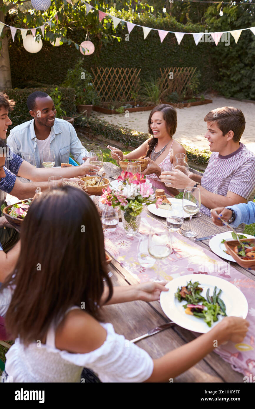 Friends Eating And Drinking Around Table At Outdoor Party Stock Photo ...
