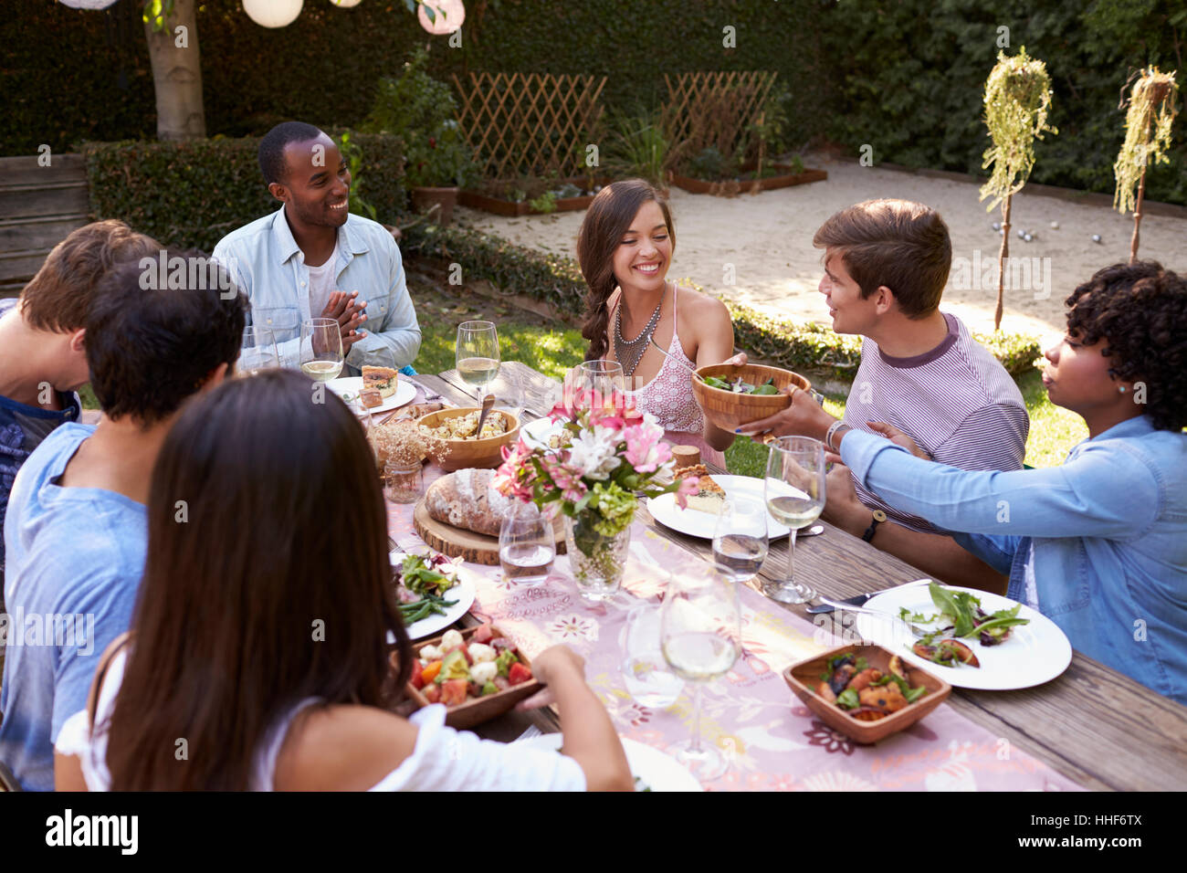 Friends Eating And Drinking Around Table At Outdoor Party Stock Photo ...