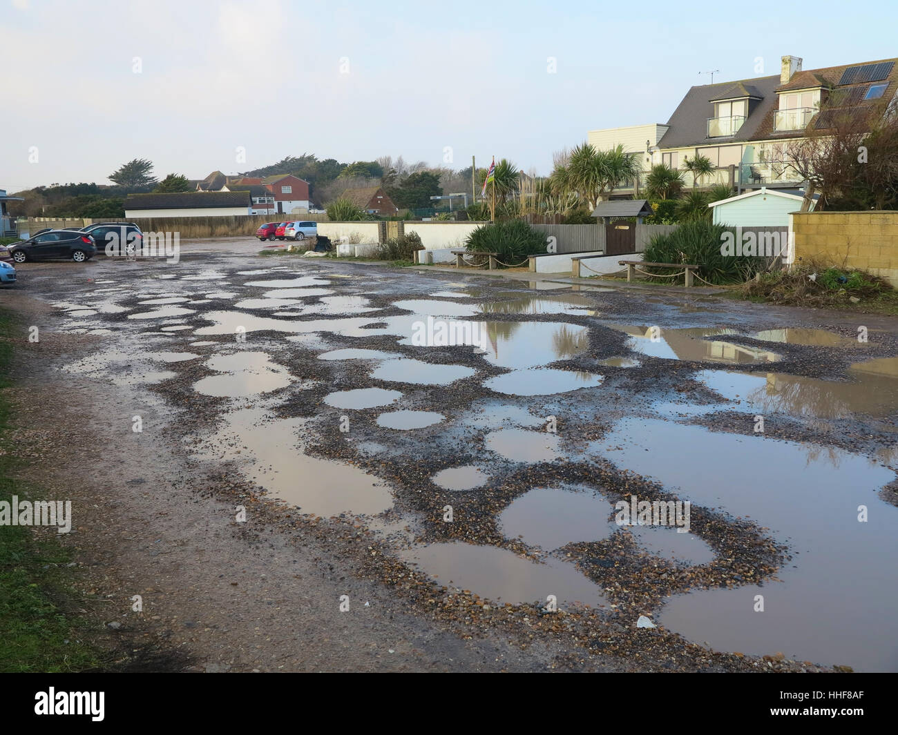 Deep potholes in car park filled with rain Stock Photo - Alamy