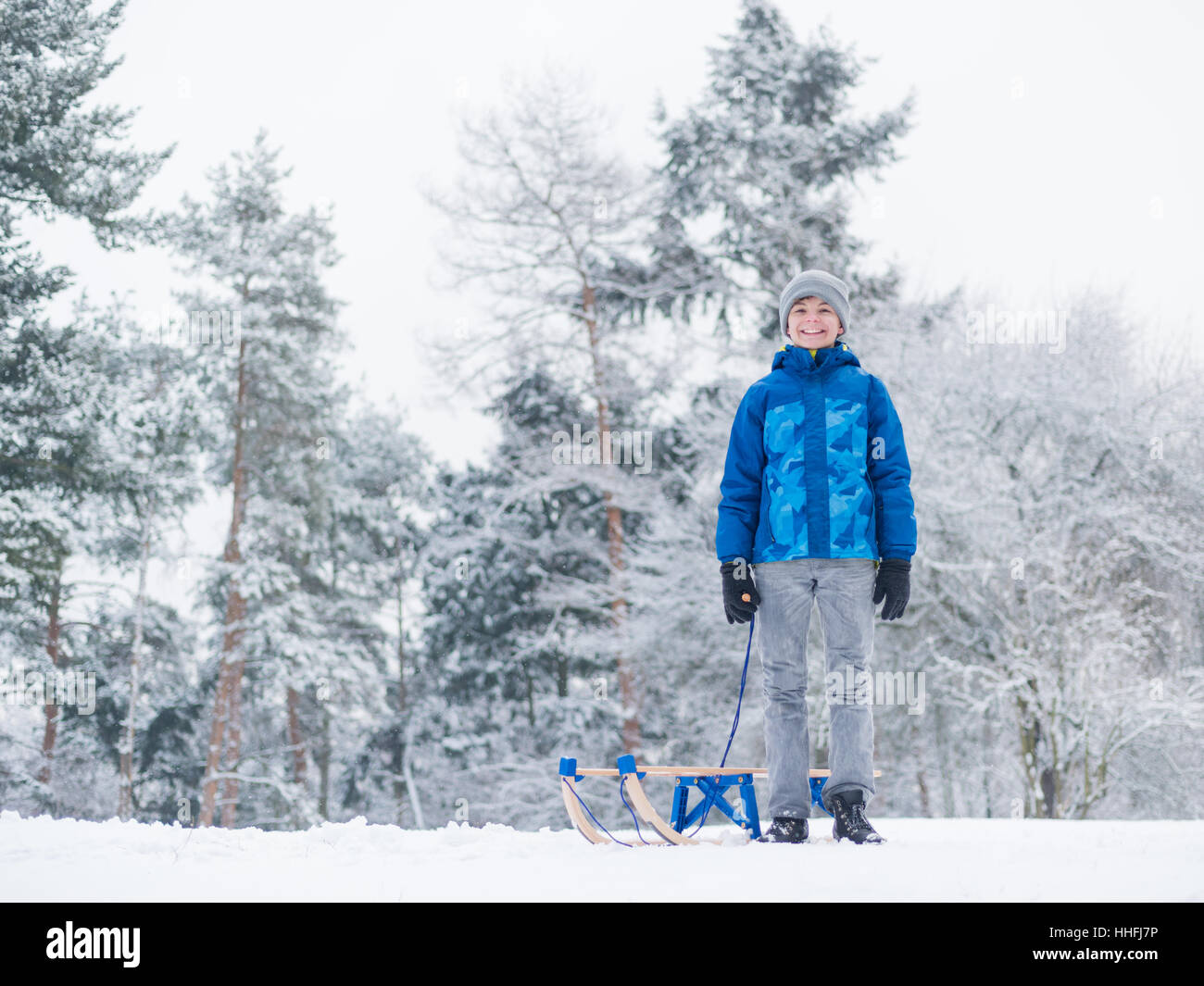 Child play in snow with sled Stock Photo - Alamy