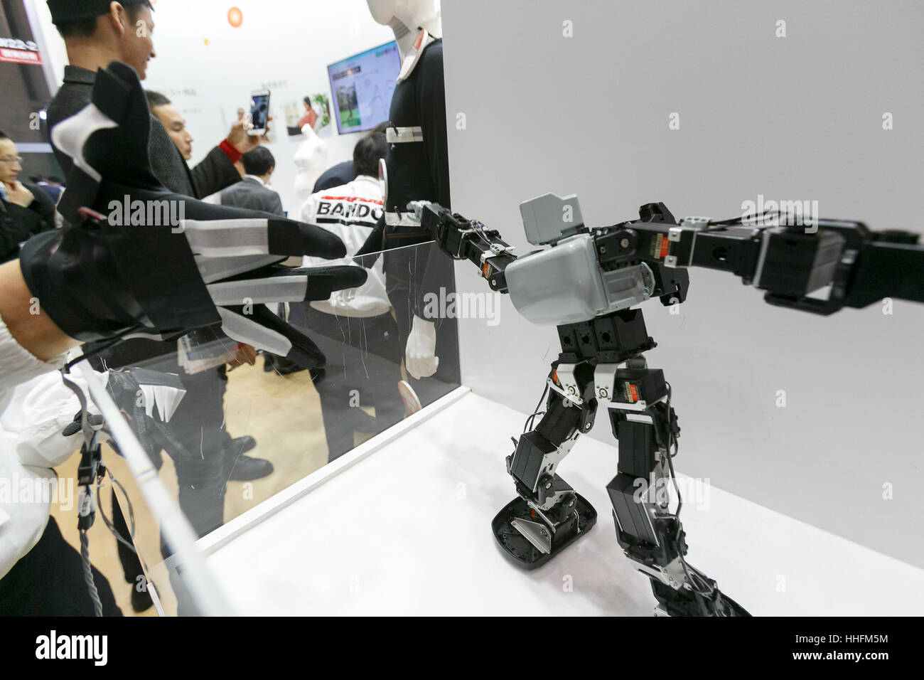 Tokyo, Japan. 18th Jan, 2017. An exhibitor controls a robot with a ...