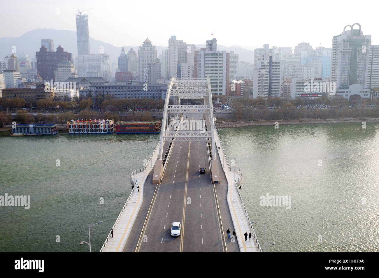 Lanzhou, China. 18th Jan, 2017. Cars run on the Yuantong Bridge across ...