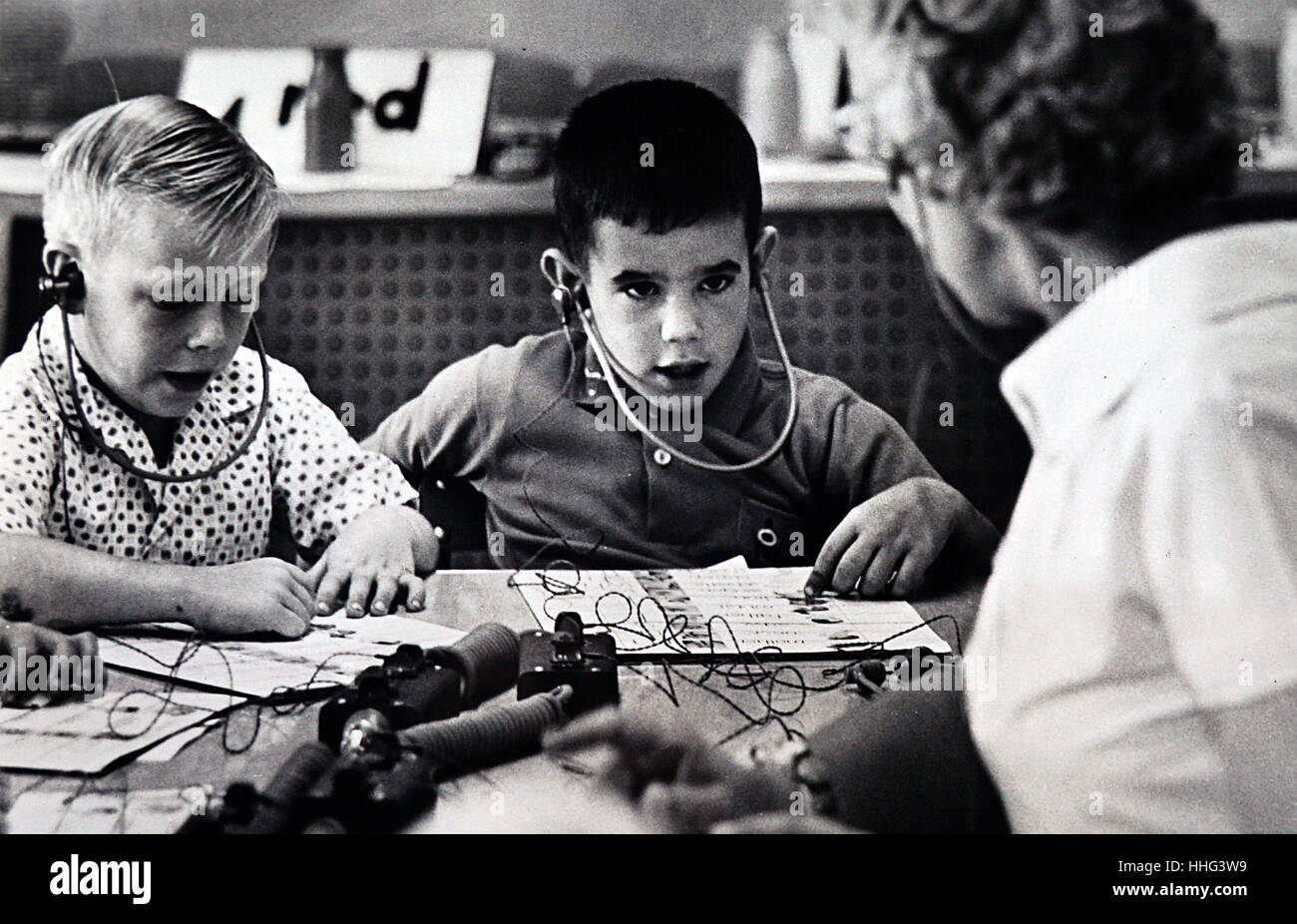 Photograph of children testing electronic machines that are teaching ...