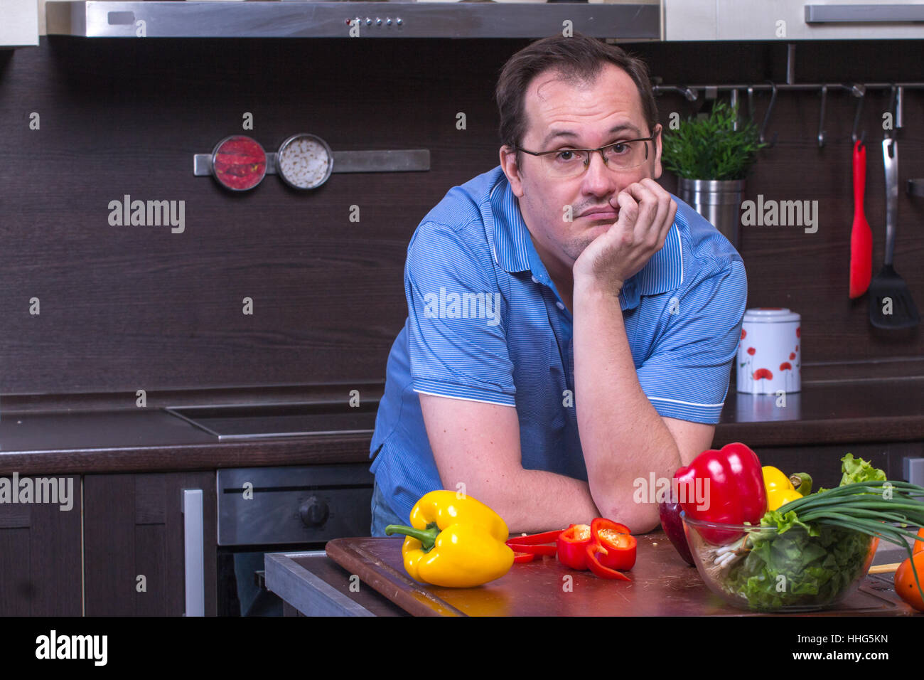 Portrait of adult sad man cooking in the kitchen, problem prepare ...