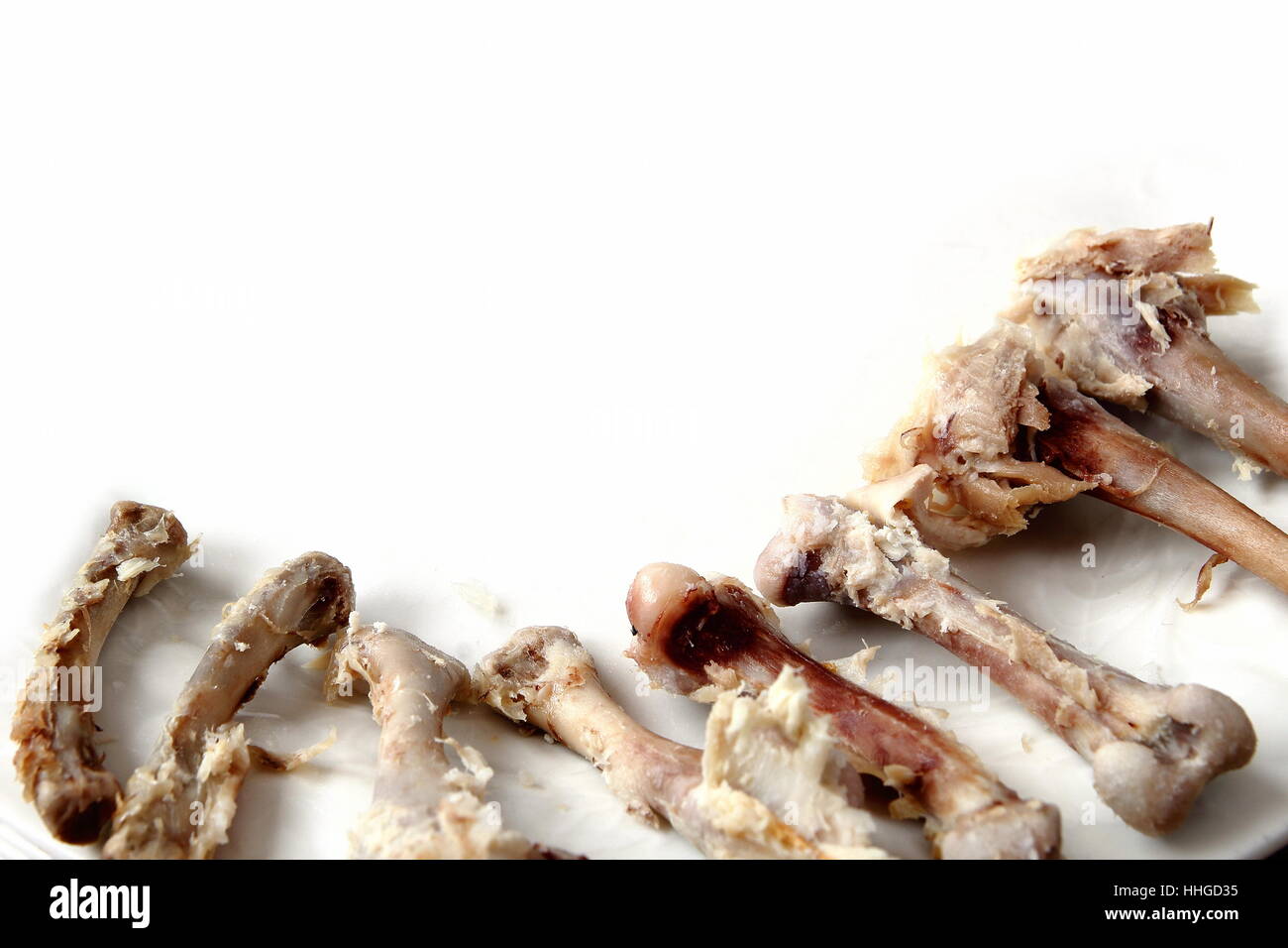 Chicken bones with meat scraps on a white background Stock Photo - Alamy
