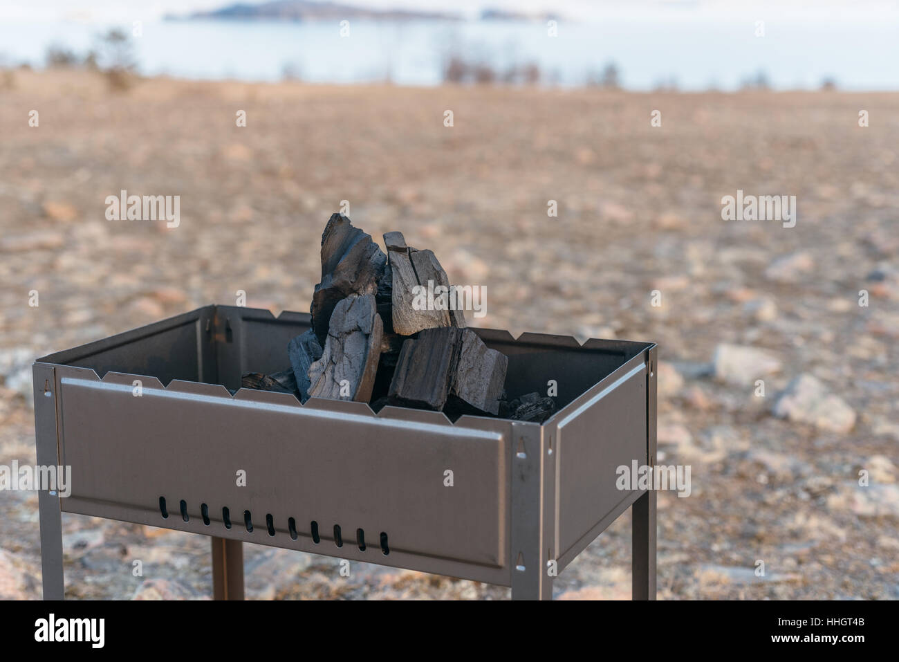 Barbecue stands on the shore of scenic Lake Baikal at sunset. It poured ...