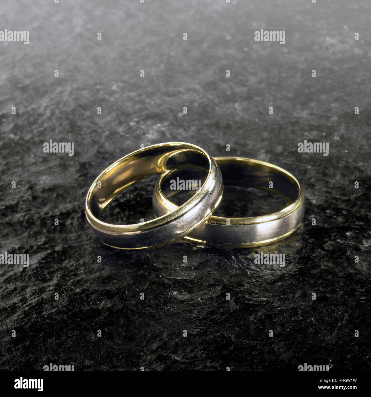 two golden wedding rings on stone surface Stock Photo - Alamy