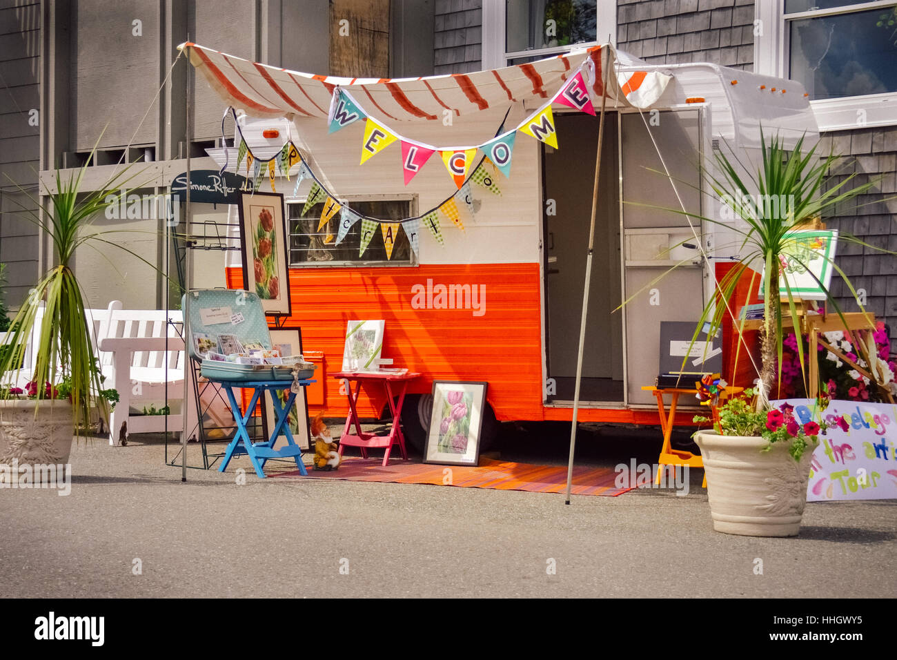 A retro camper trailer decorated to sell charming crafts on a sunny ...