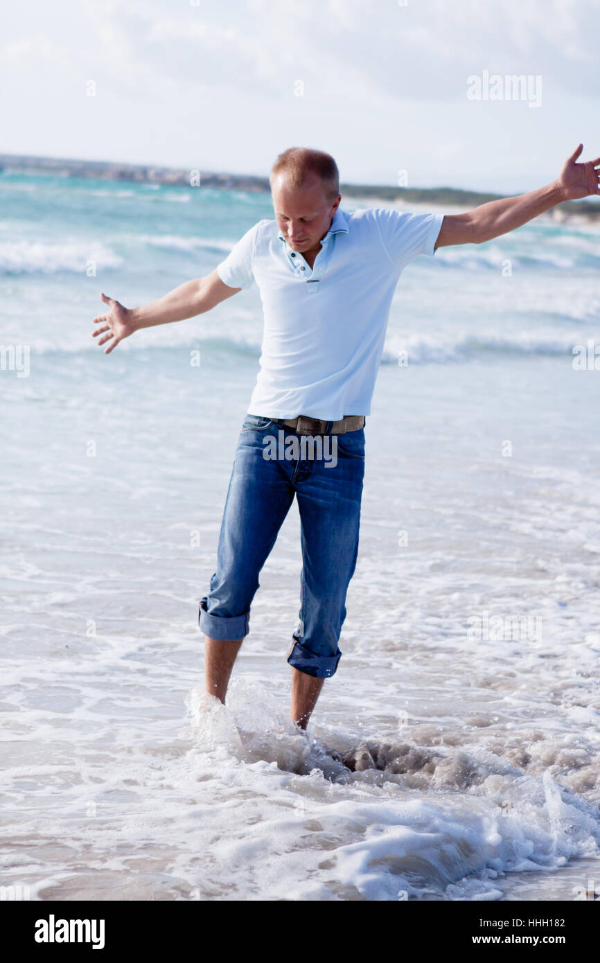 young man relaxing on the beach by the water in the summer Stock Photo ...