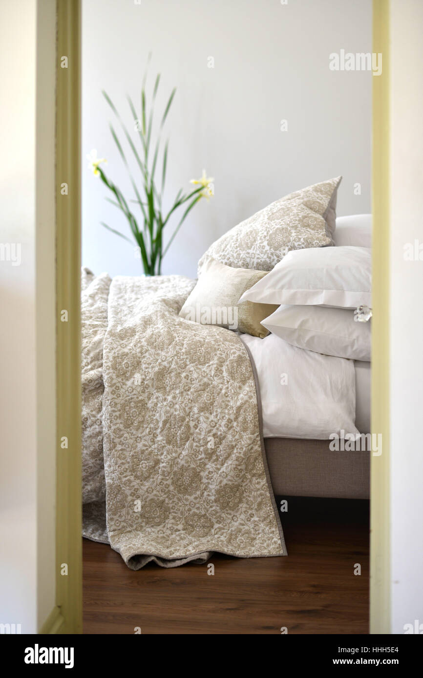 Bed in bedroom setting with luxury bedspread Stock Photo - Alamy