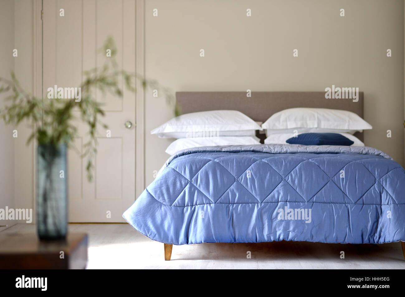 Bed in bedroom setting with luxury bedspread Stock Photo - Alamy