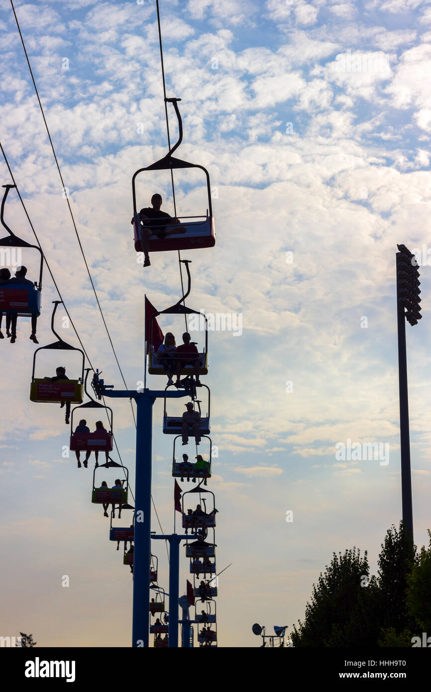 People in the chair lift agaist a sunset sky during the Canadian ...