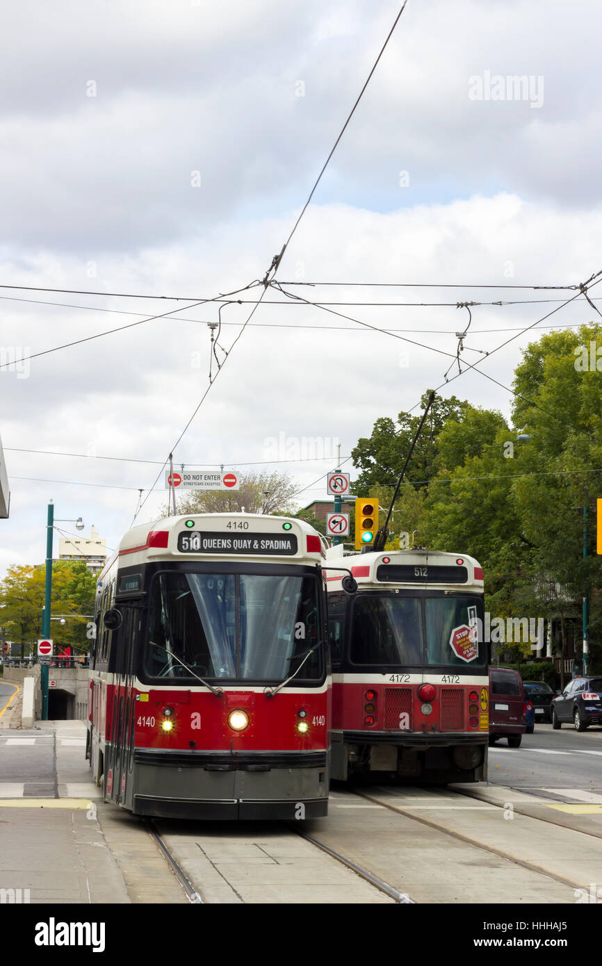 Front view of two old style street car travelling southbound on Spadine ...